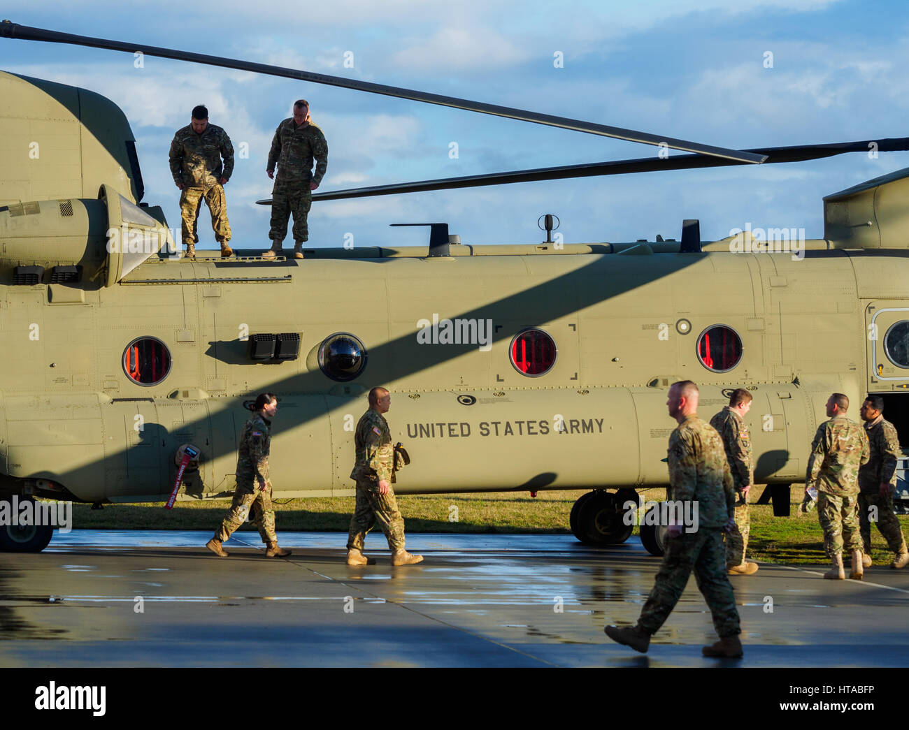Illesheim, Germany. 9th Mar, 2017. US soldiers walk past a Boeing CH-47 ...