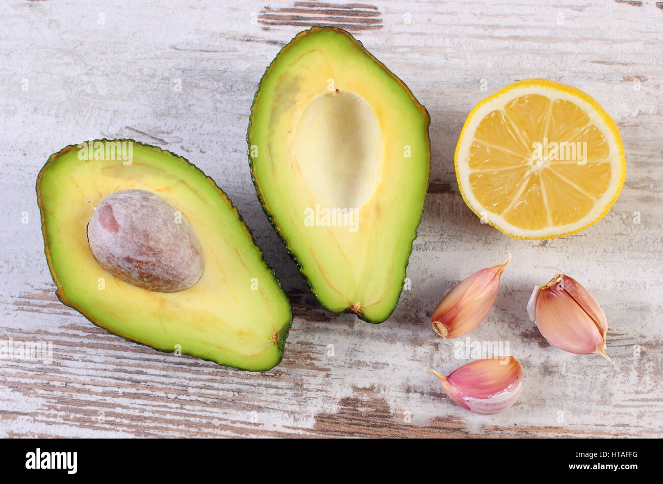 Portion of avocado, clove garlic and lemon, concept of healthy food ...