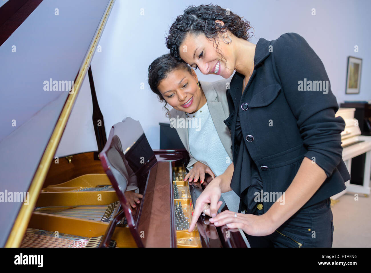 Women looking at piano Stock Photo - Alamy