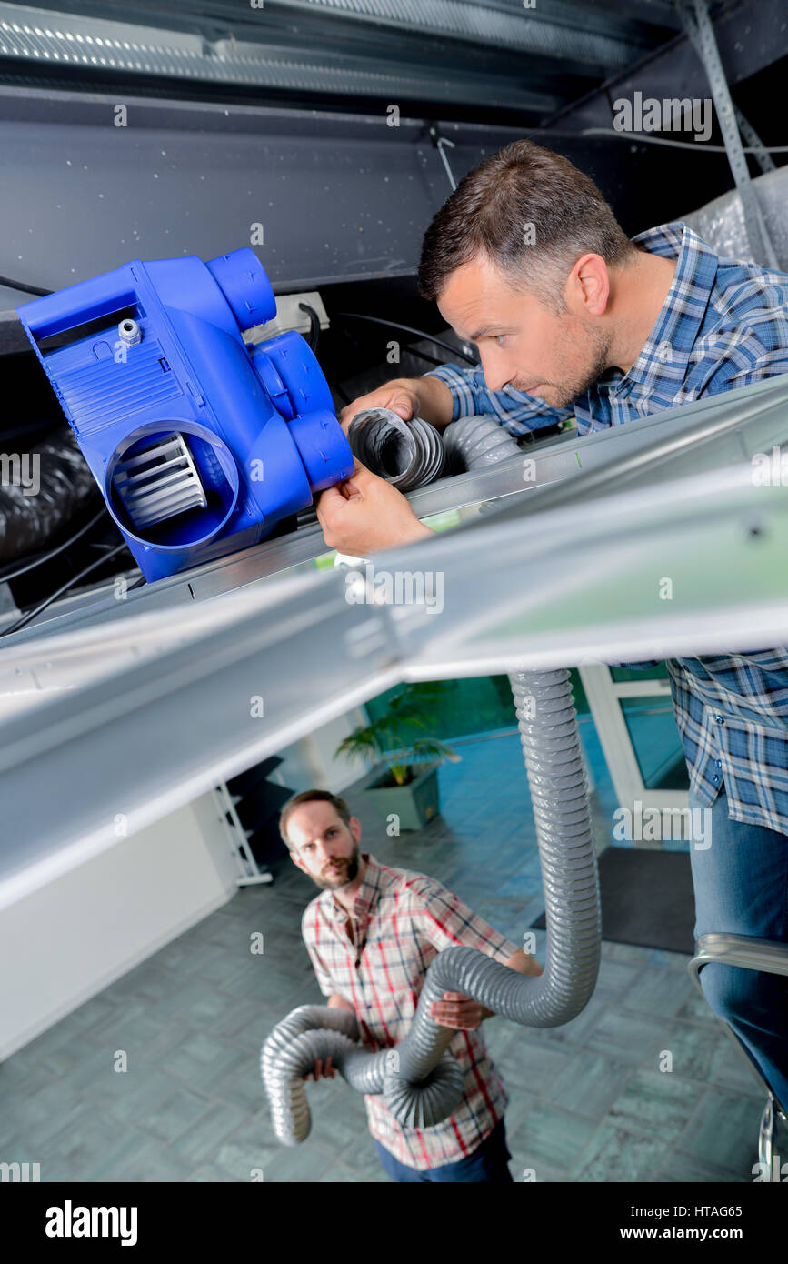 Man repairing ventilation system Stock Photo - Alamy
