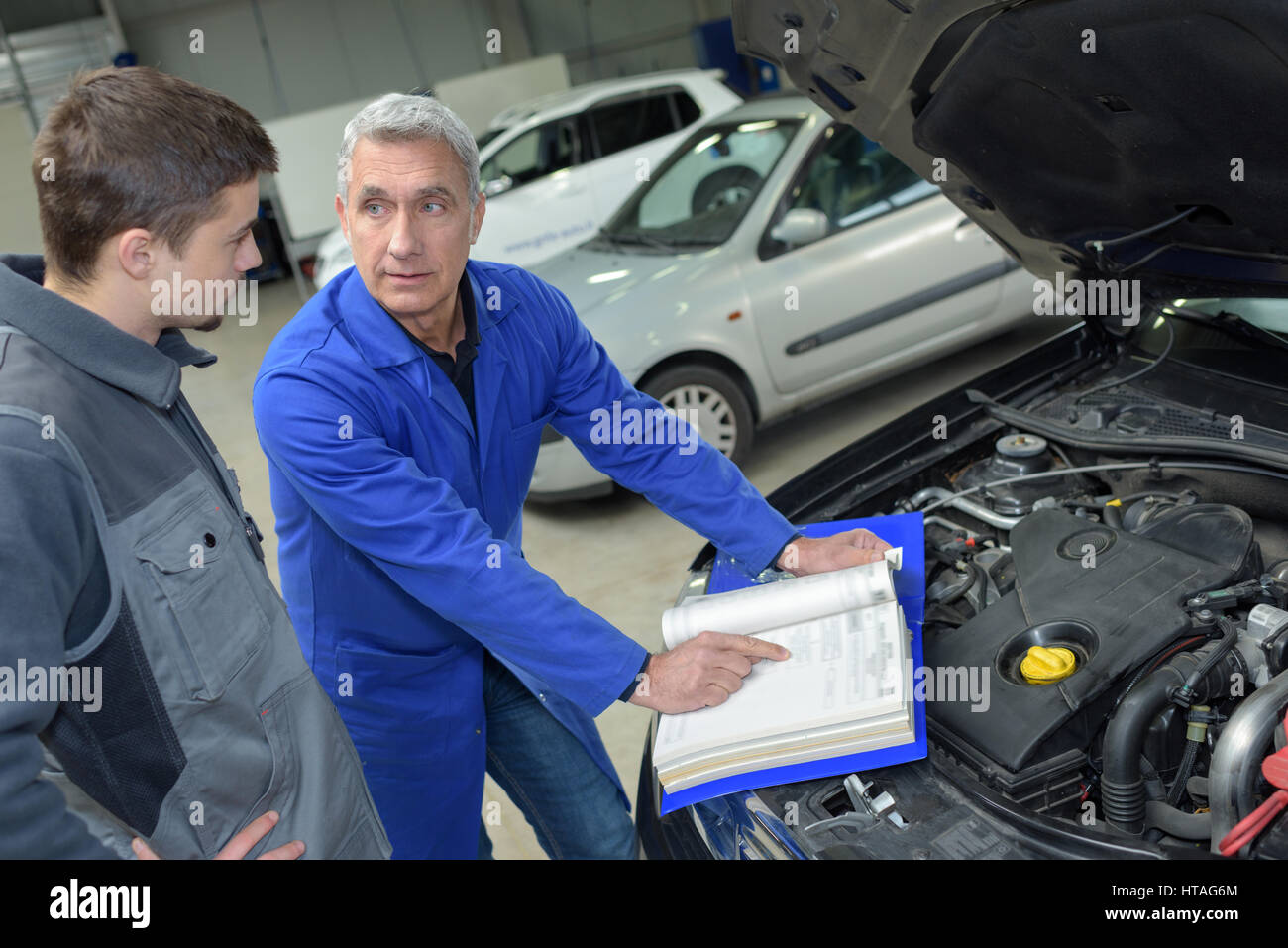 mechanic helping trainee to fix engine Stock Photo - Alamy