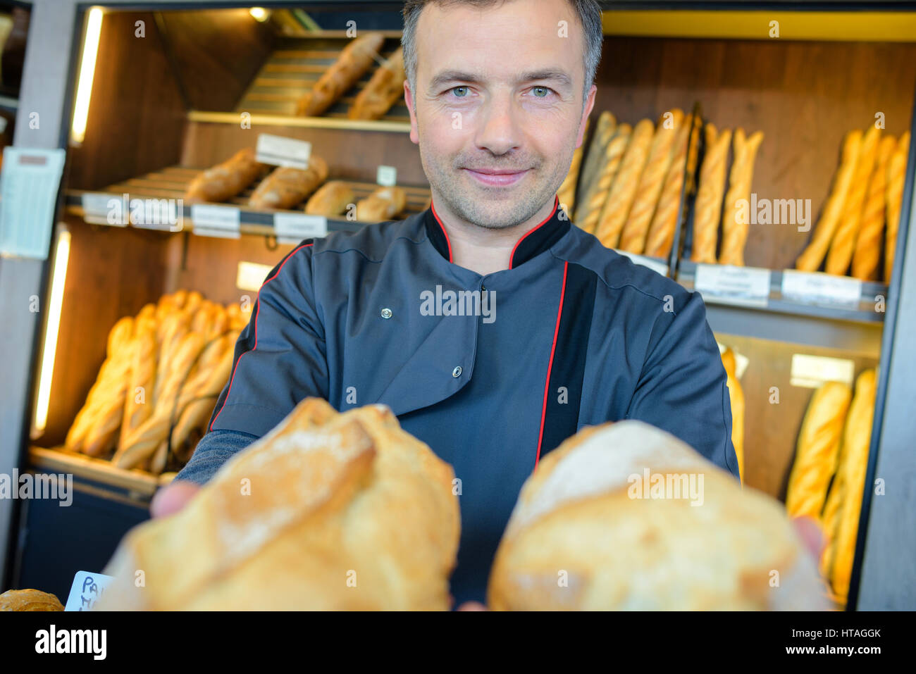 bakery shopkeeper is proud of his bread production Stock Photo - Alamy