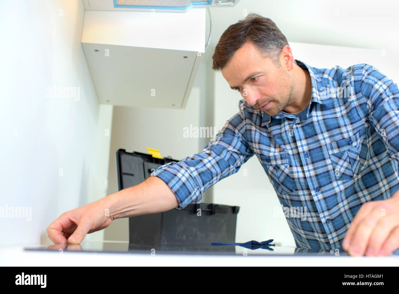 Fitting a new kitchen hob Stock Photo - Alamy