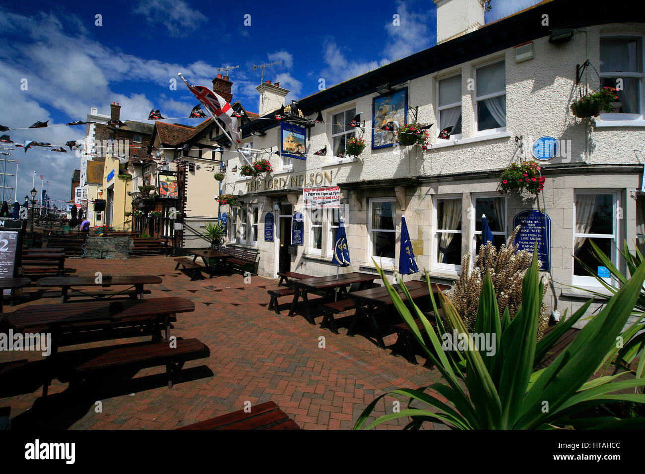 Empty tables outside classic English pub on a Summer's day with flowers ...