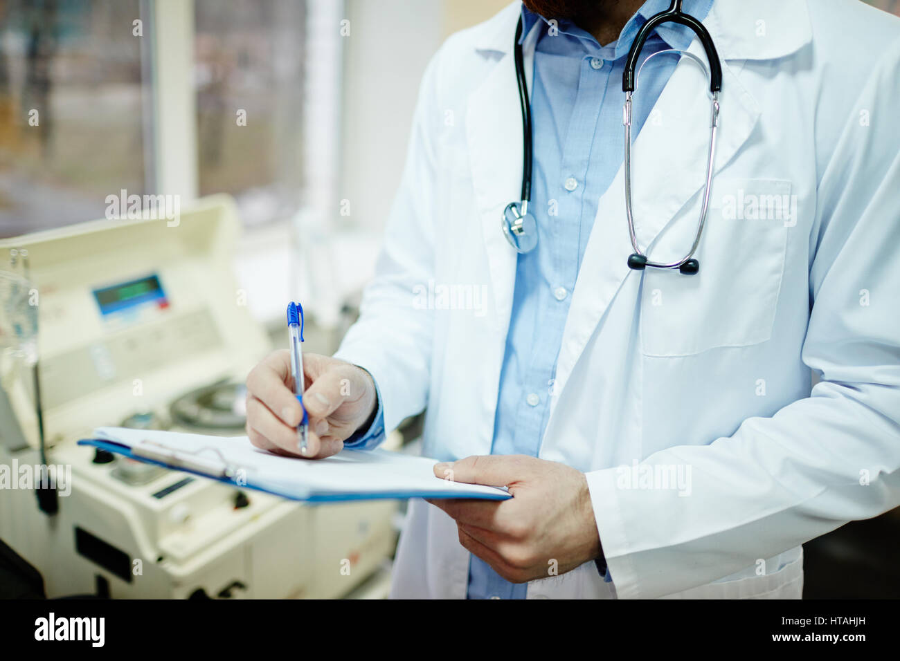 Clinician writing notes on clipboard hi-res stock photography and ...