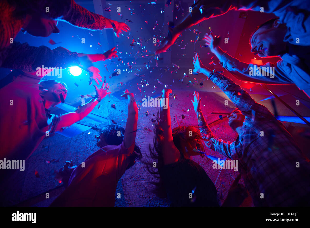 Friends having fun with confetti while dancing Stock Photo - Alamy