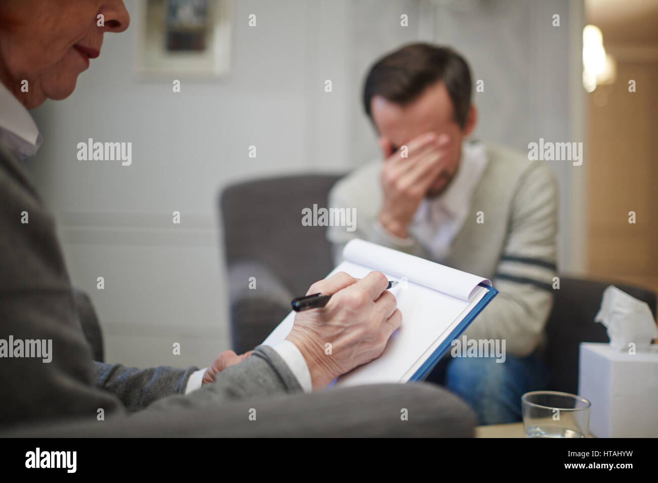 Psychologist making notes while patient telling his story Stock Photo ...