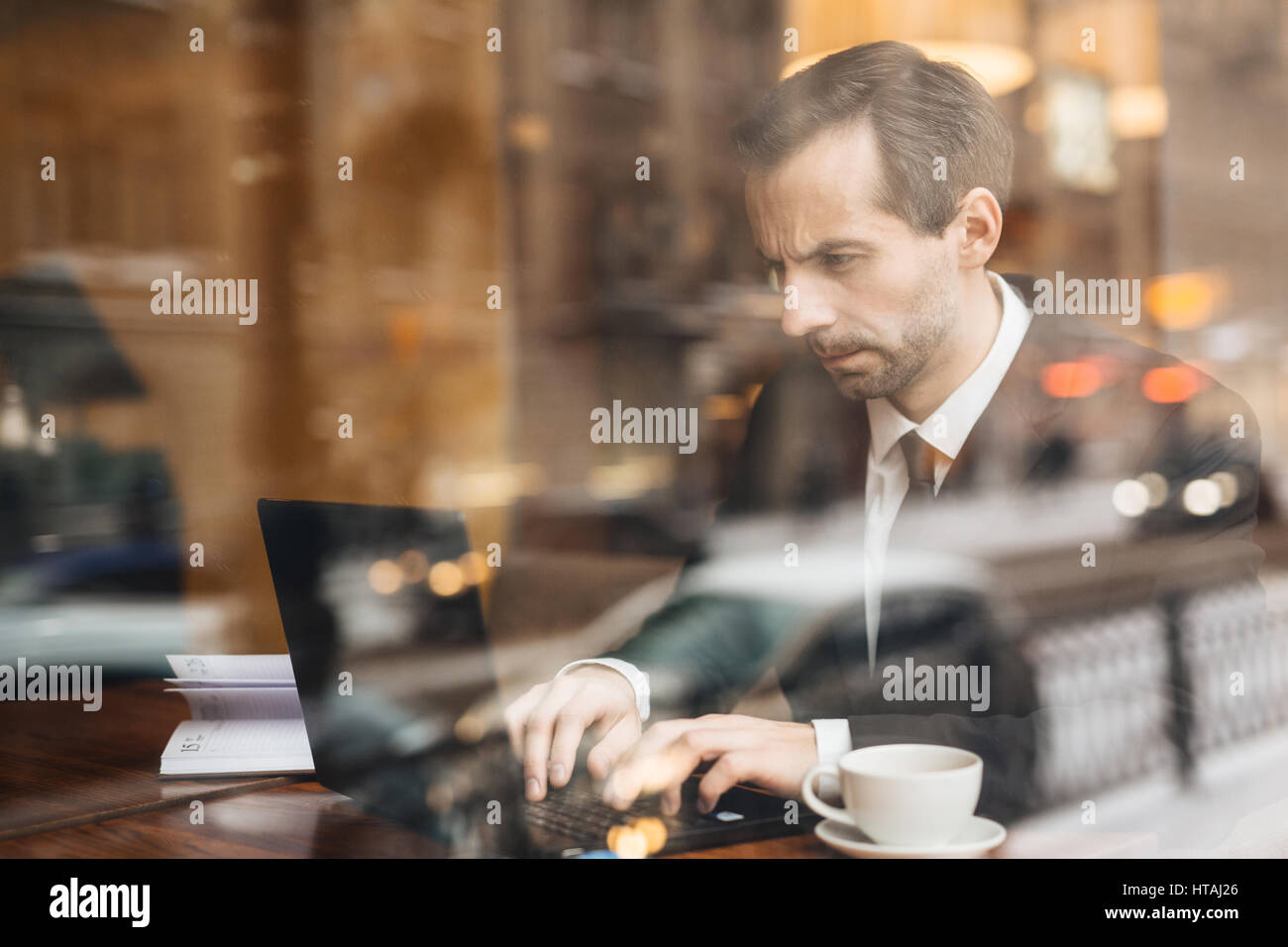 Successful middle-aged businessman frowning with concentration while ...