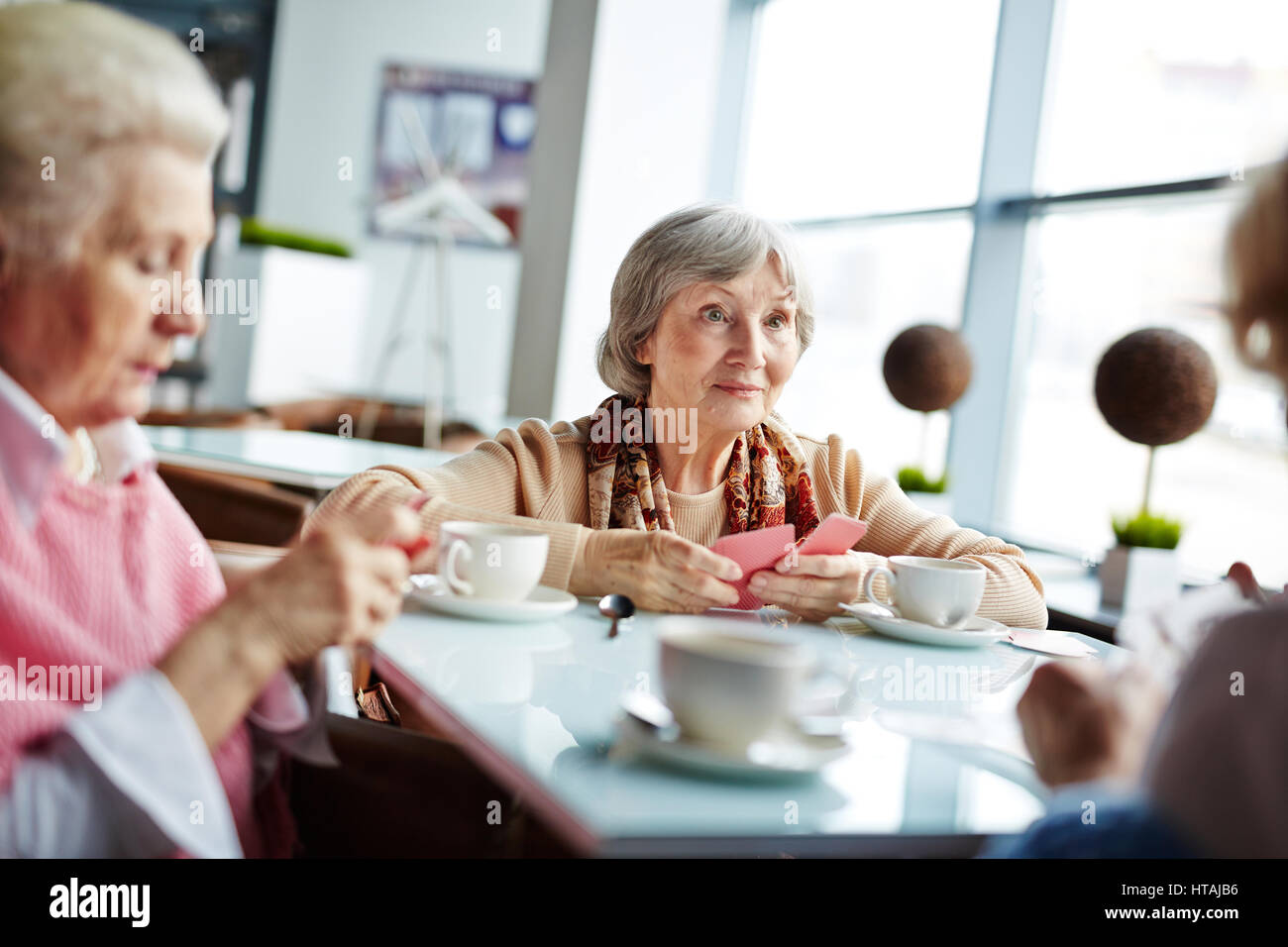 Senior women playing bridge game in cafe Stock Photo - Alamy