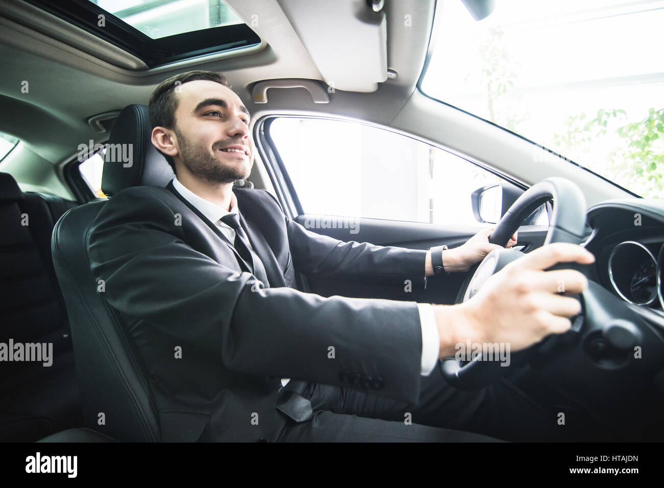 young businessman in his car. Driver of luxuty car. Handsome man drive ...