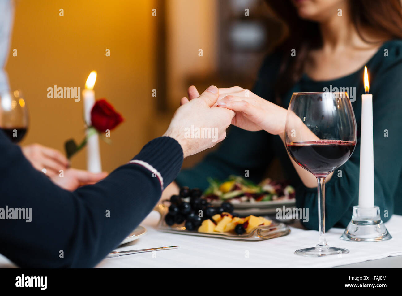 Hands of man and woman during romantic dinner Stock Photo - Alamy