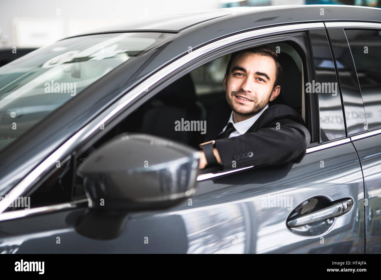 happy smiling driver in the car, portrait of young successful business ...