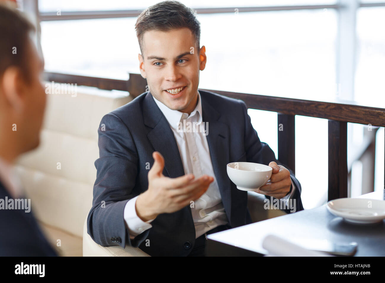 Successful businessman talking to his colleague during tea-break Stock ...