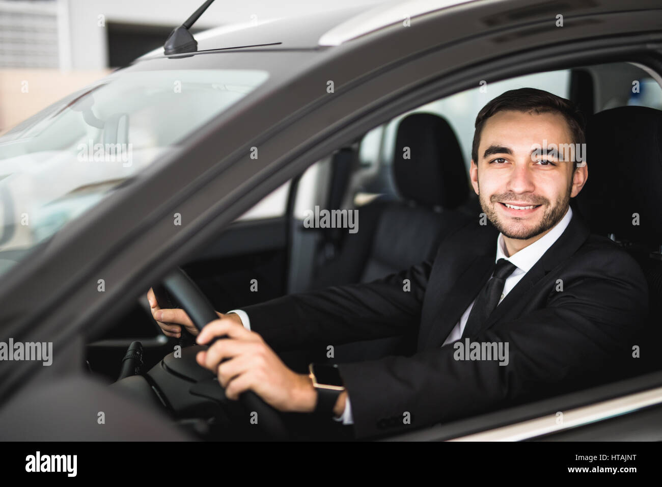 Smiling man looking from a car window with smile Stock Photo - Alamy