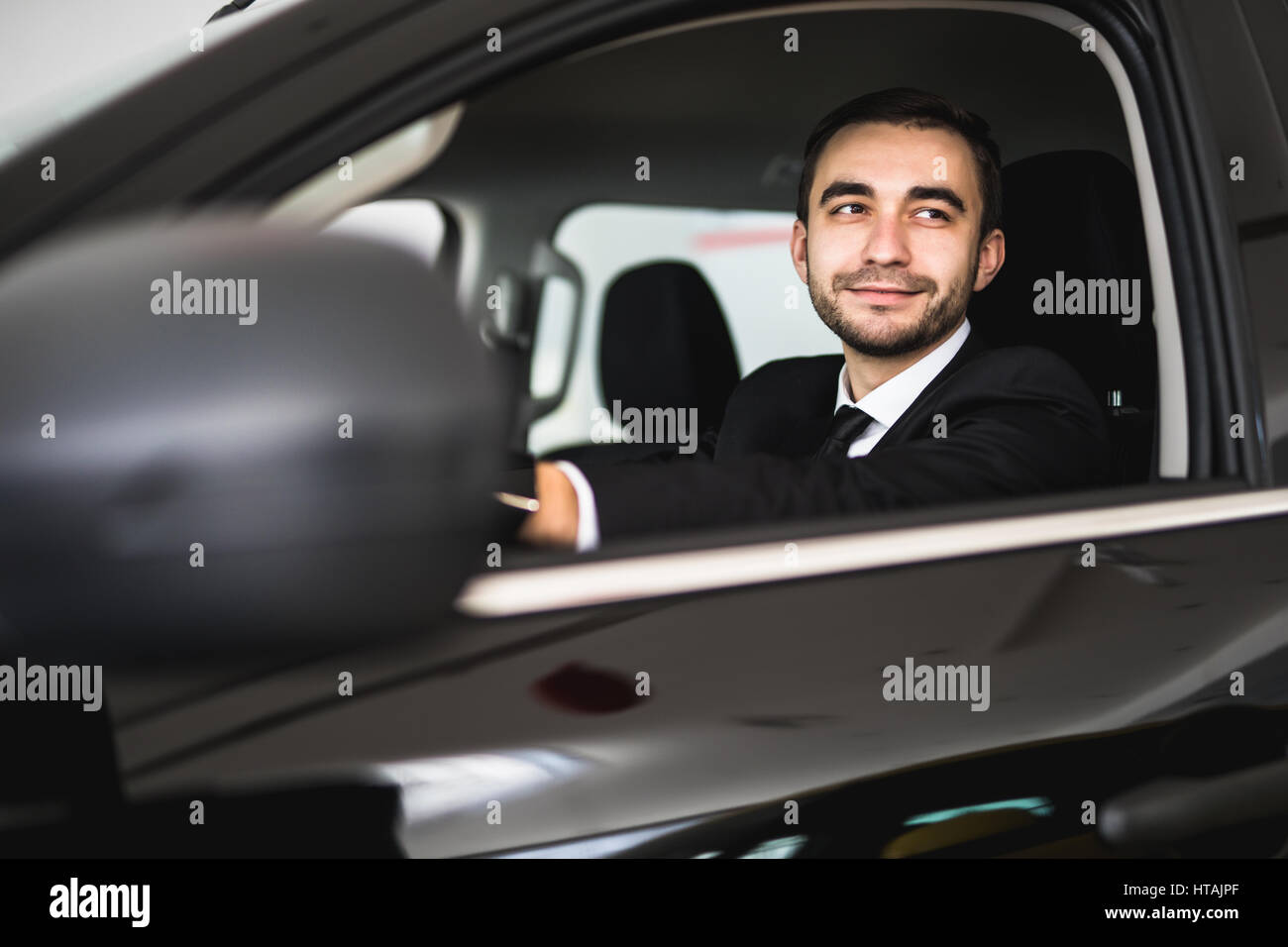 Smiling man looking from a car window with smile Stock Photo - Alamy