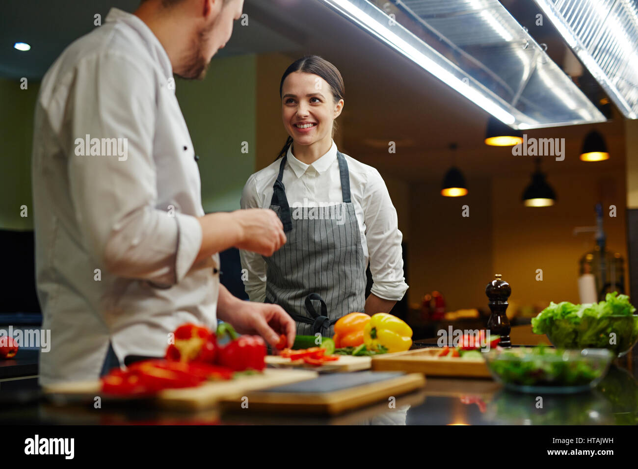 Happy young trainee talking to chef during cooking master class Stock ...