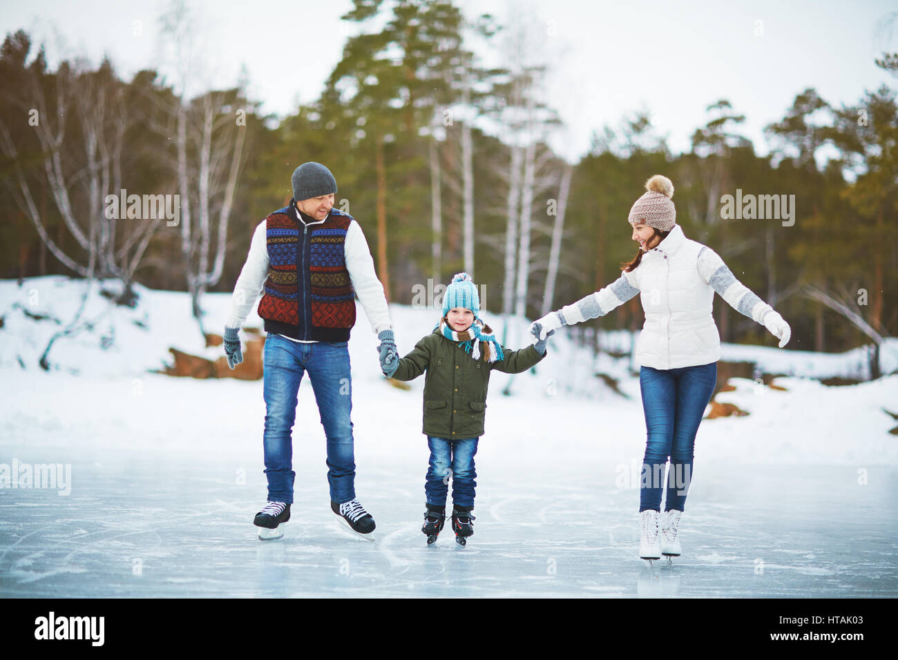 Little boy skating with his parents Stock Photo - Alamy