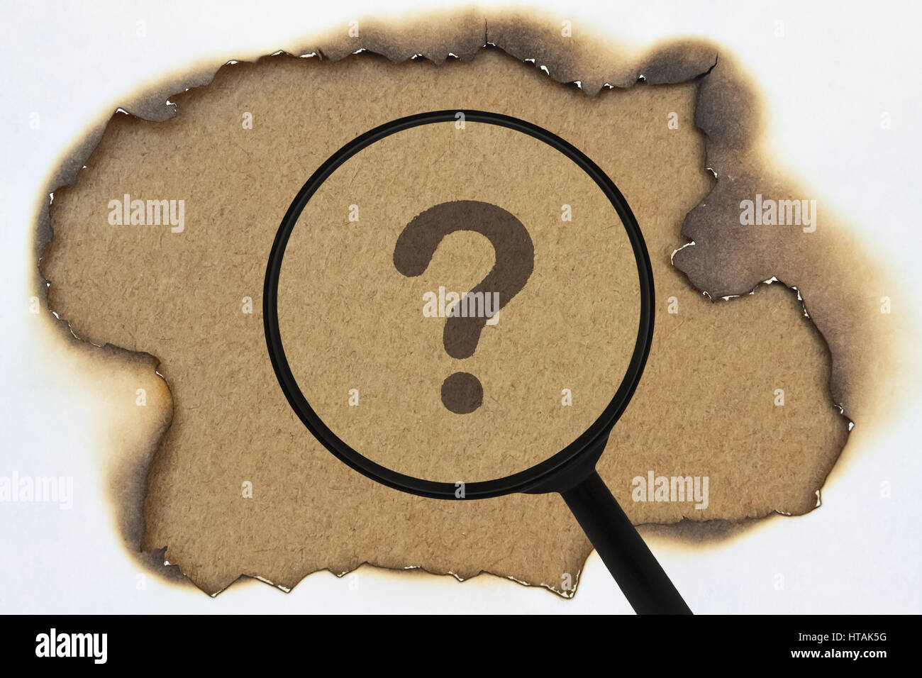 Question mark under a magnifier on burnt yellow paper Stock Photo - Alamy