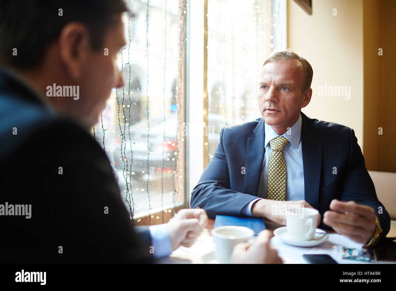 Confident banker talking to his business partner Stock Photo - Alamy