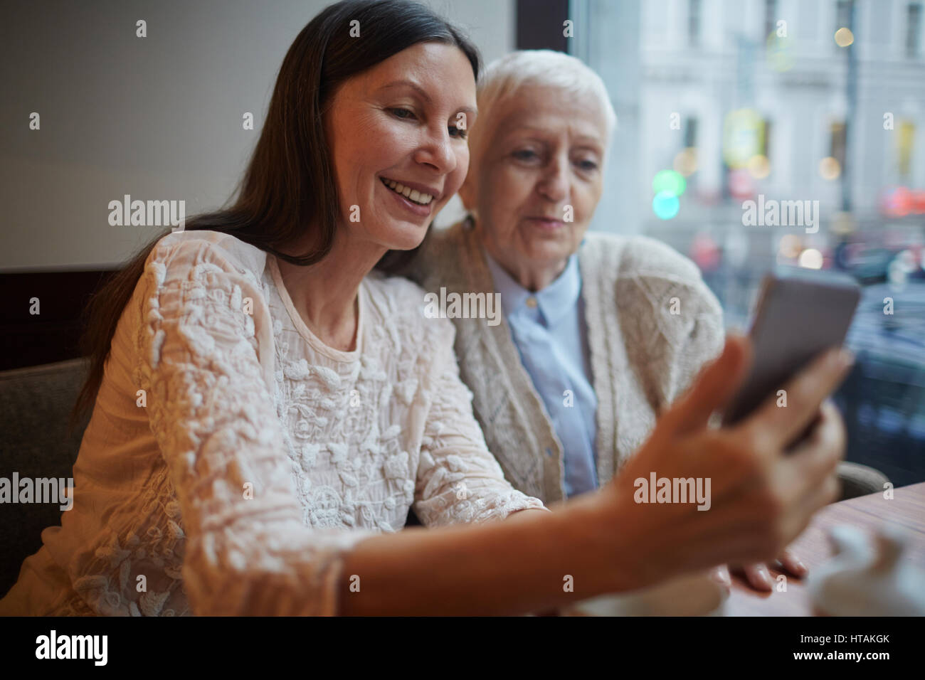 Happy woman and her buddy watching something online in smartphone Stock ...