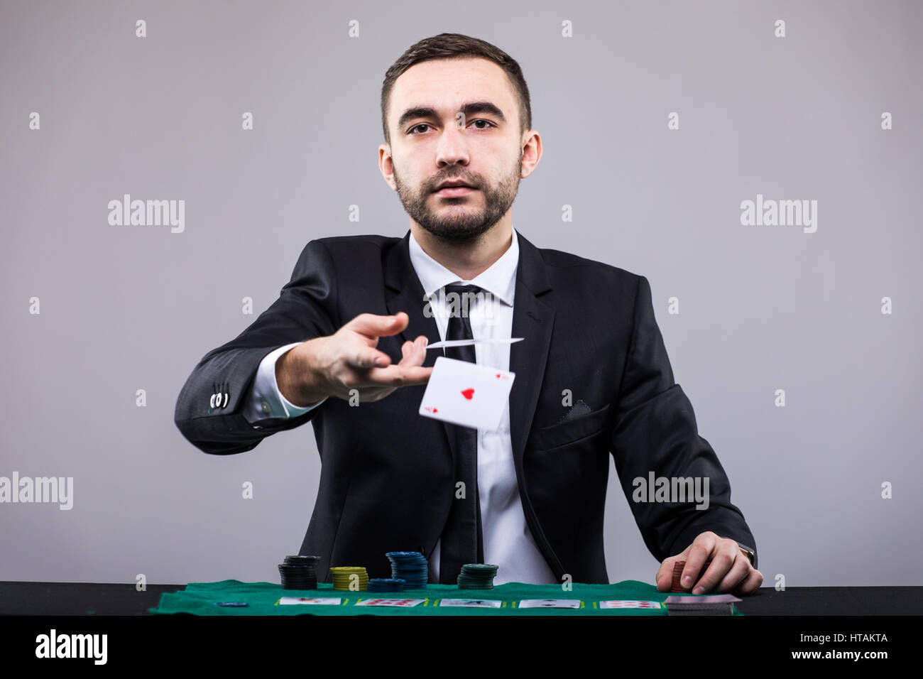Poker player, on a grey background, throwing two ace cards Stock Photo ...