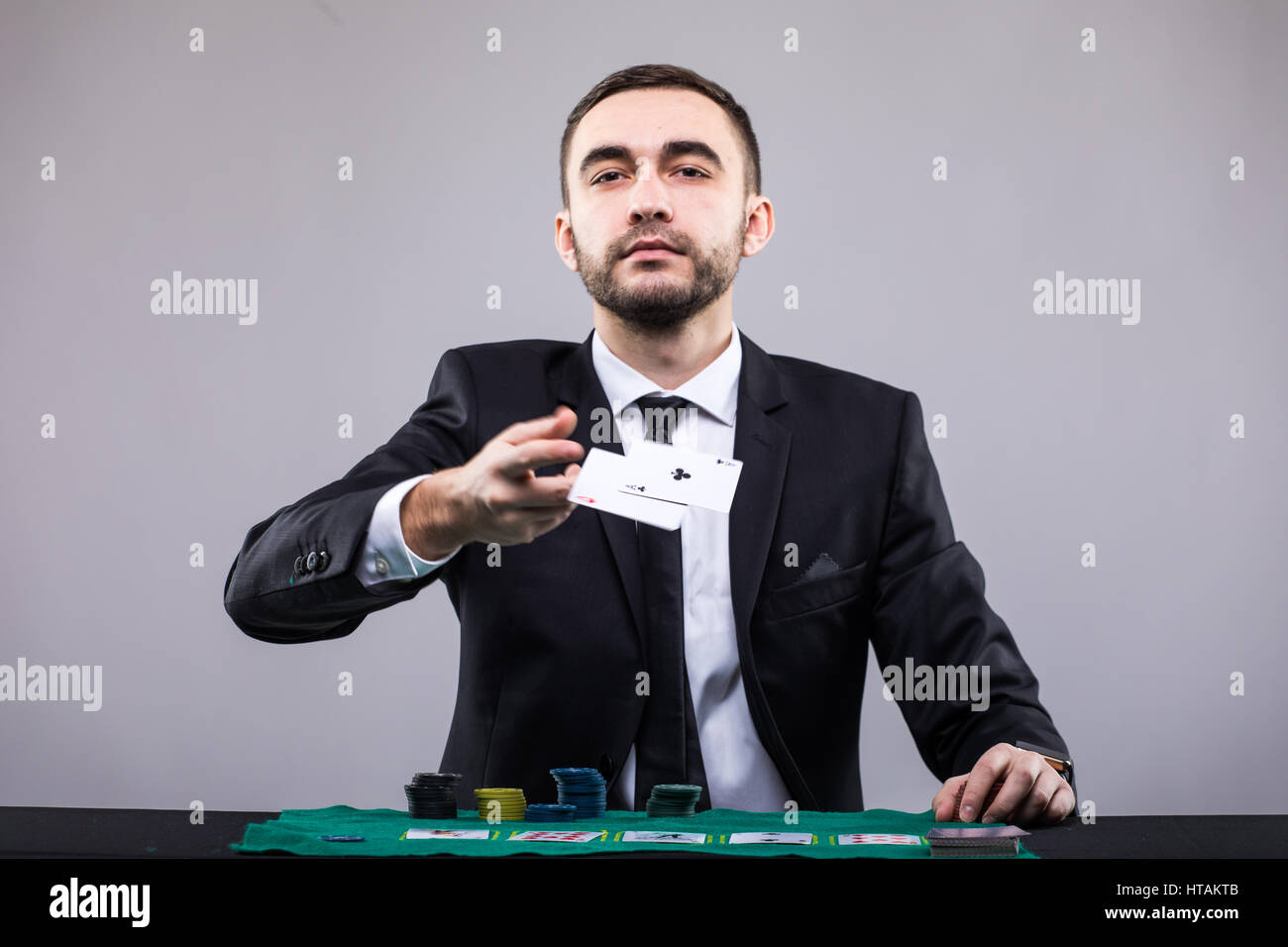 Poker player, on a grey background, throwing two ace cards Stock Photo ...