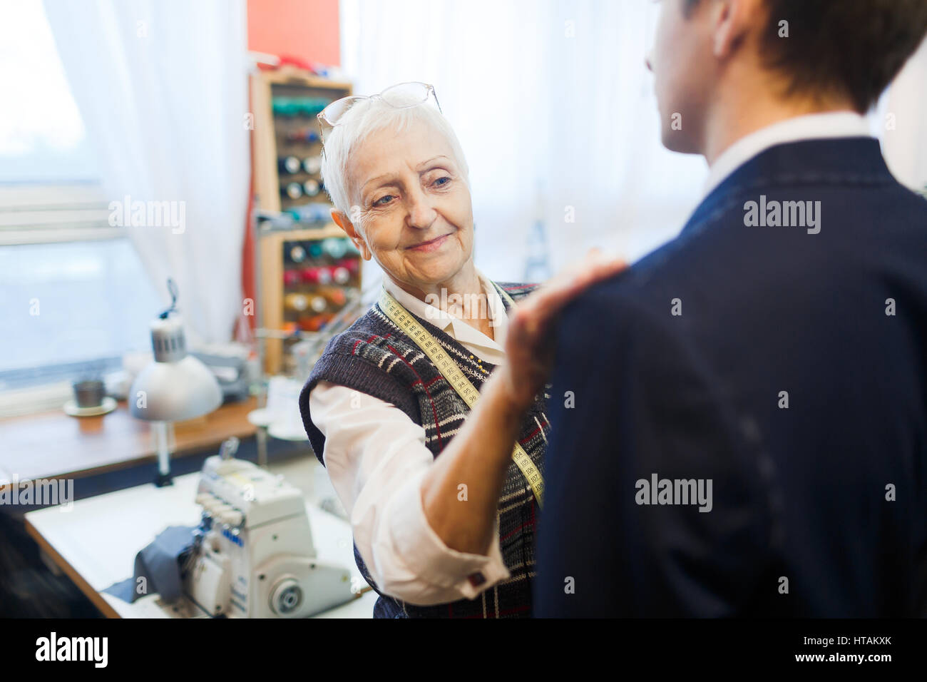 Dressmaker working with her client in tailoring-shop Stock Photo - Alamy