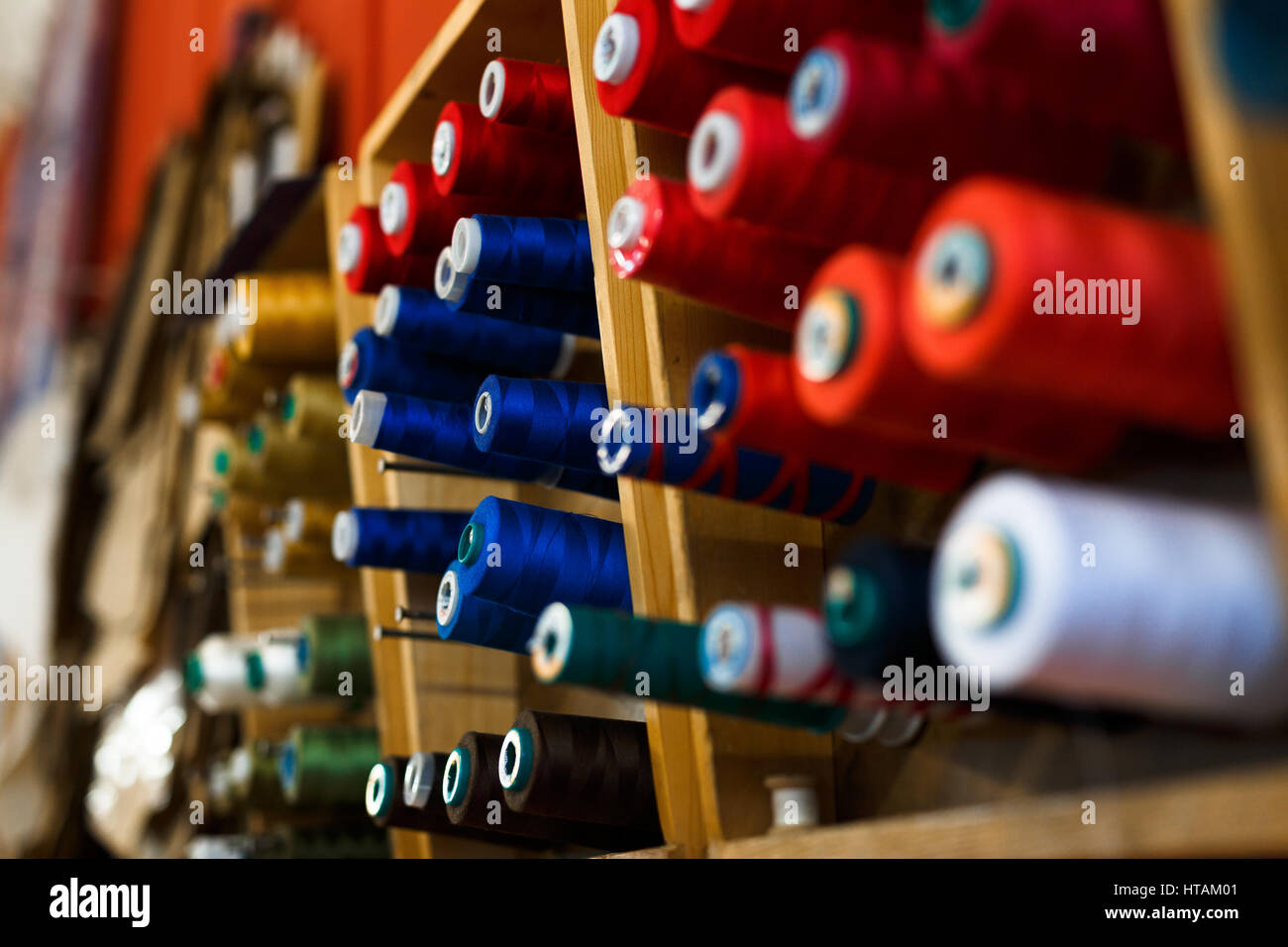 Set of multi-colored spools in workshop of tailor Stock Photo - Alamy