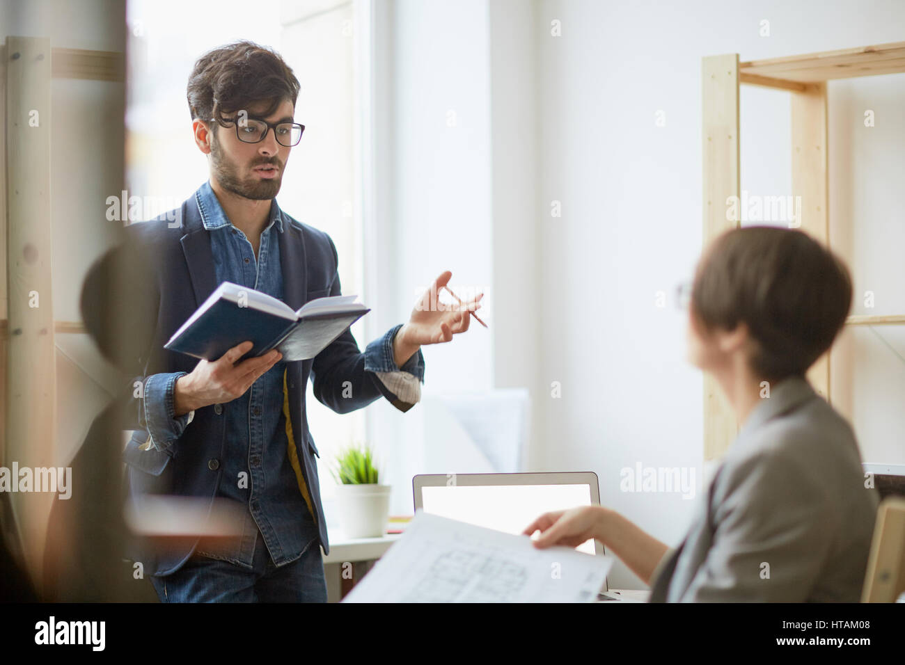 Portrait of two employees talking in office: successful project manager ...
