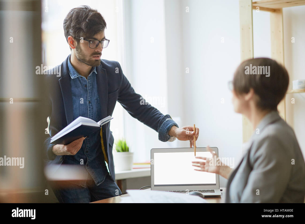 Two colleagues discussing ideas together in office, arguing about ...