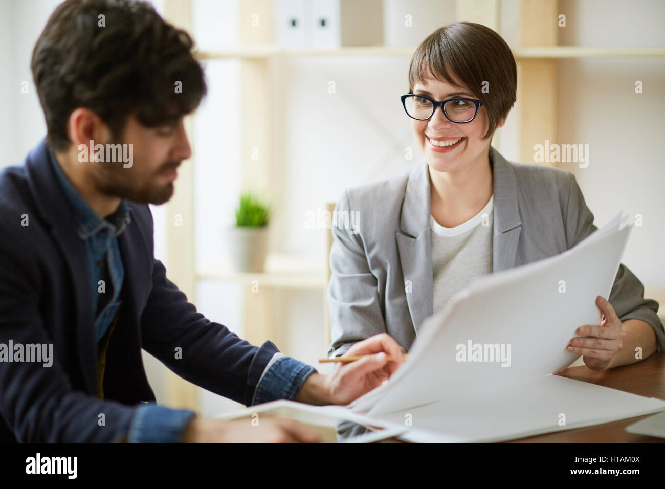 Portrait of two smiling colleagues making final decisions discussing ...