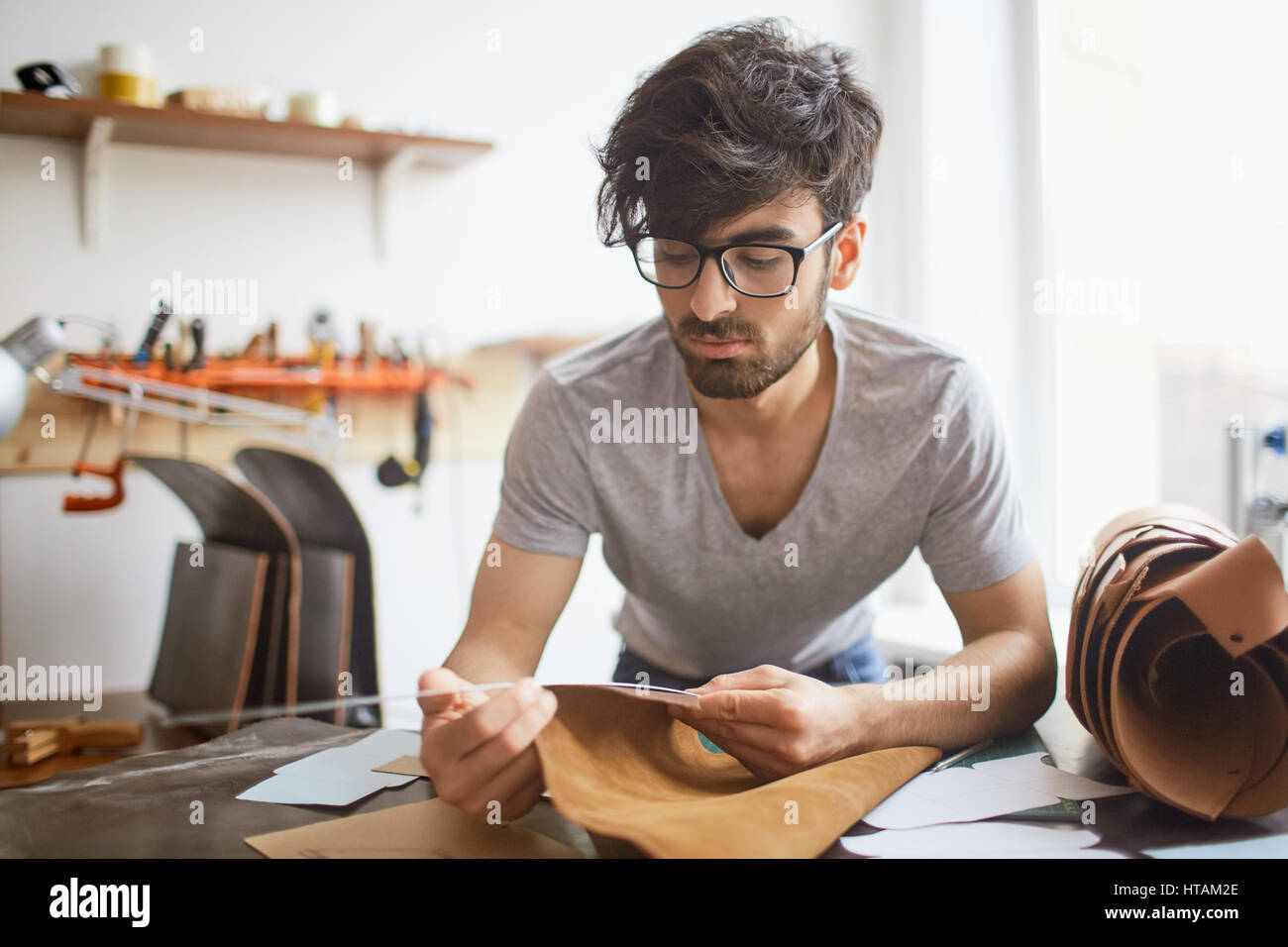 Portrait of modern handsome craftsman wearing creative haircut and ...