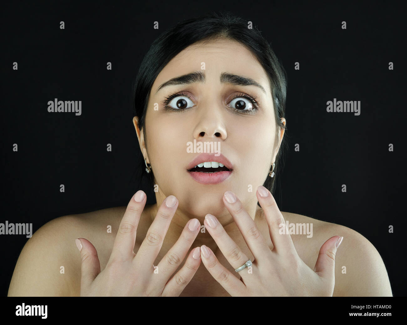 beautiful young girl holding hands near face, excited, scared standing ...