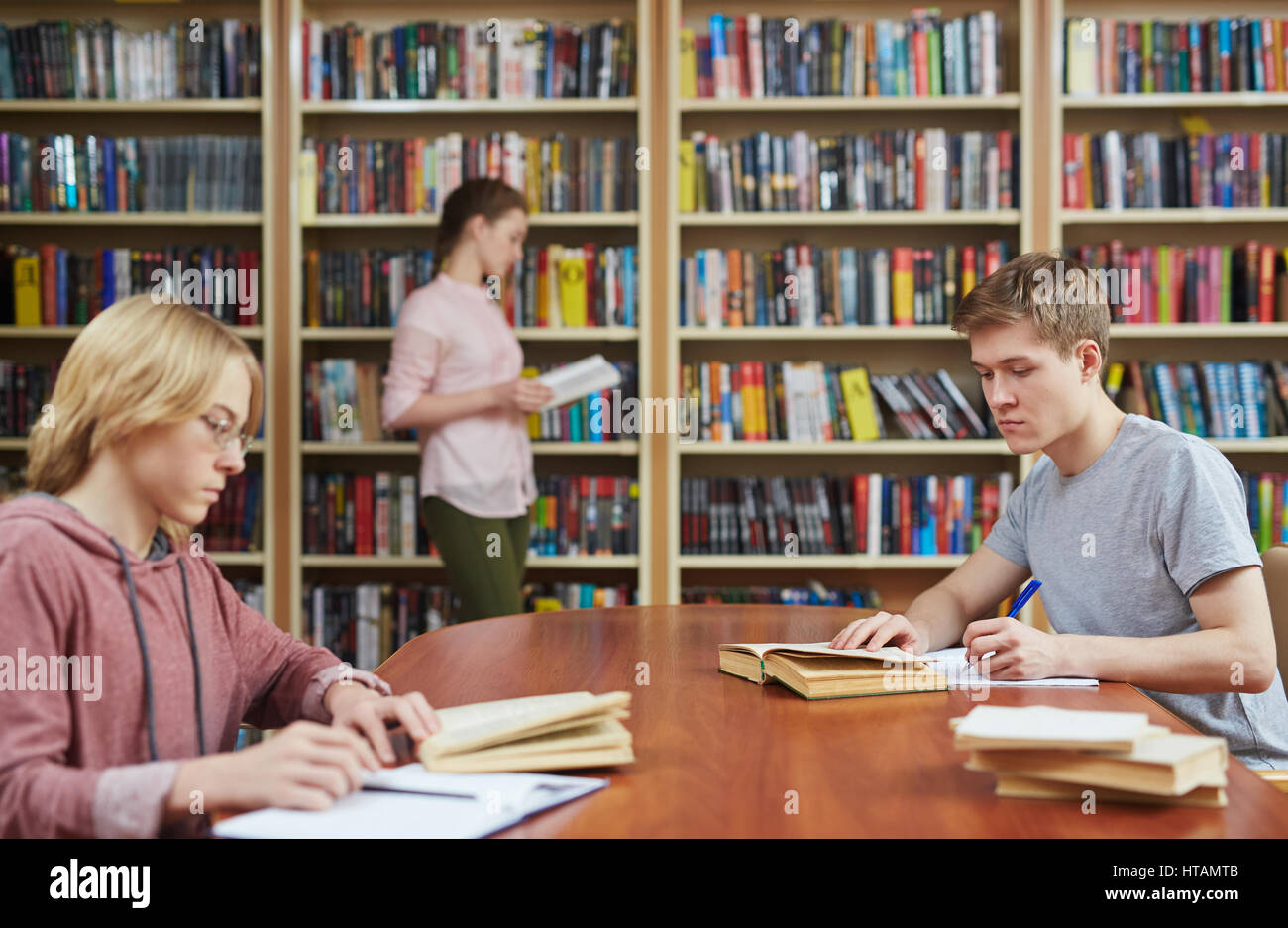 Two guys reading books and rewriting information into copybooks Stock ...