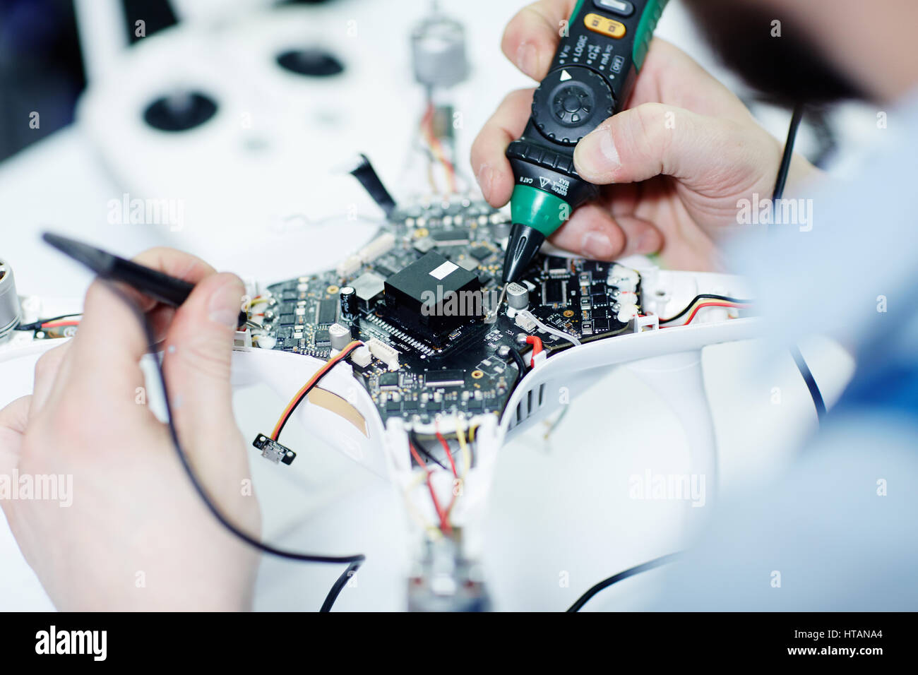 Closeup top view shot of male hands testing electric current in circuit ...