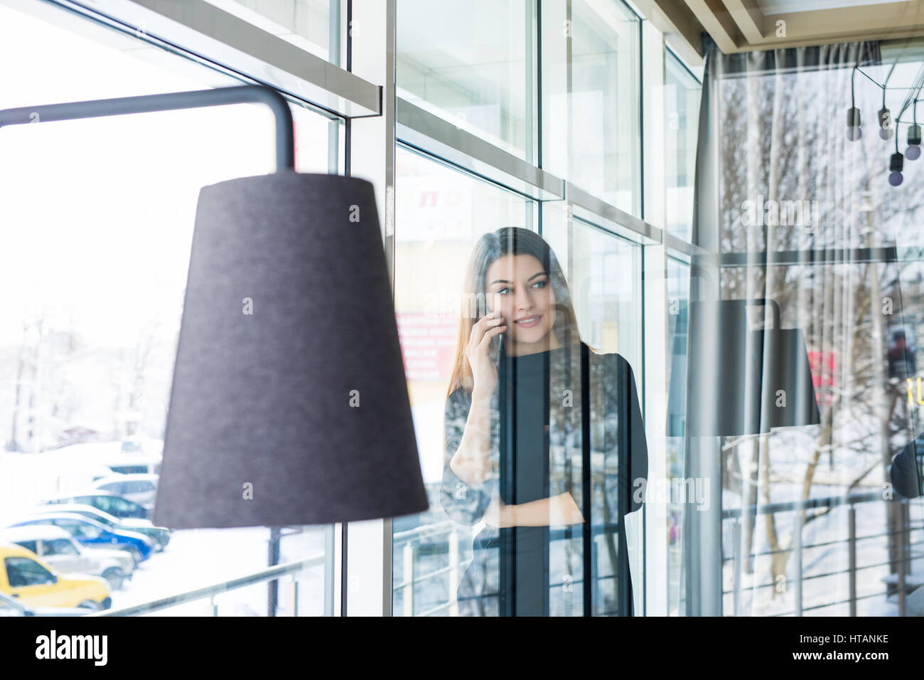 View though the window beautiful woman having cell telephone ...