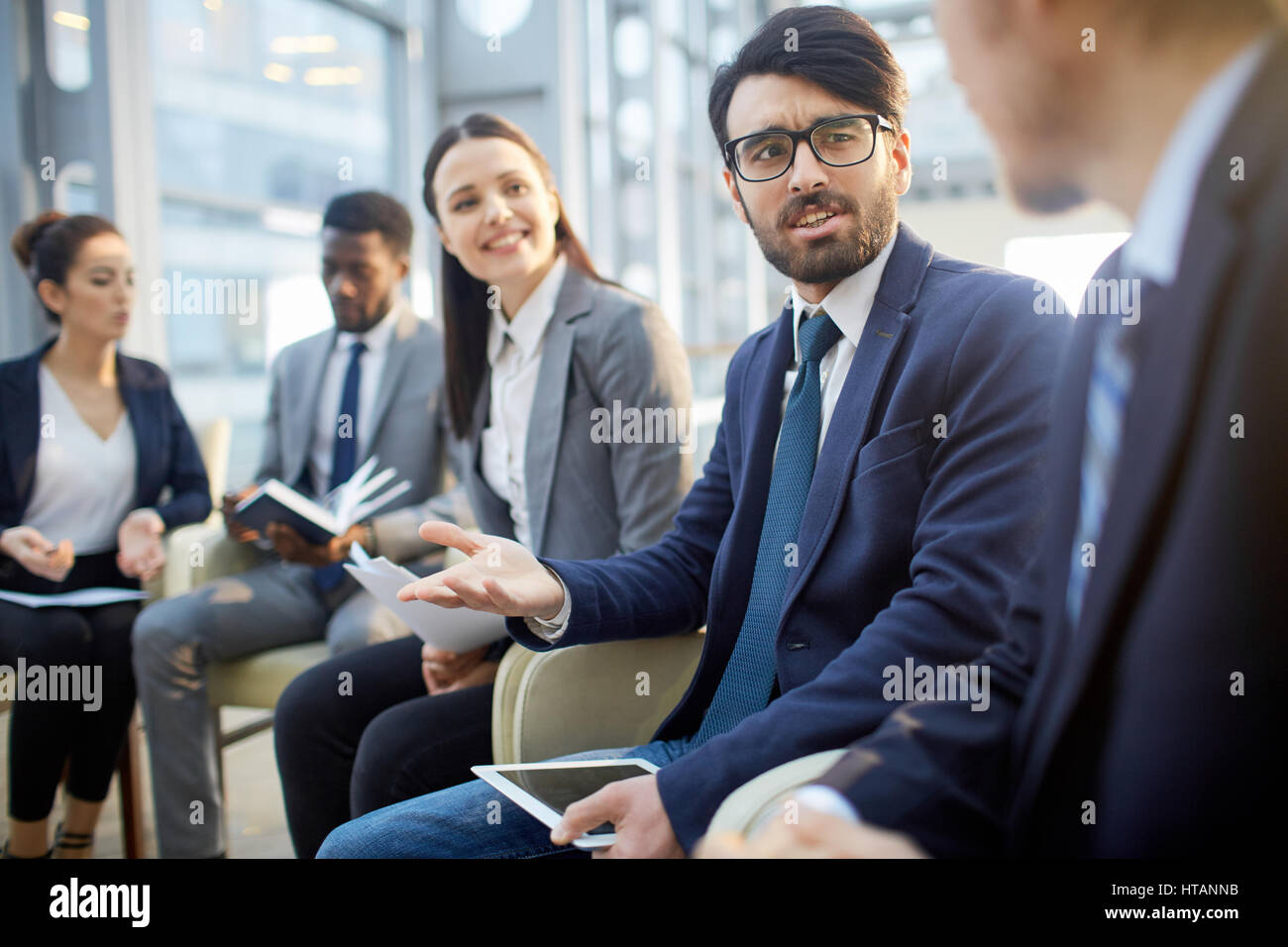 Young manager explaining financial data to one of his colleagues Stock ...