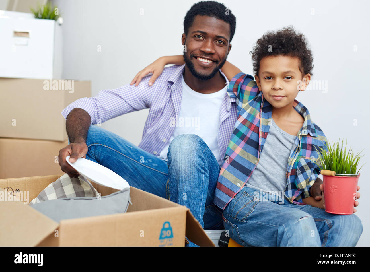 Little son and his father unpacking things from carton box Stock Photo ...