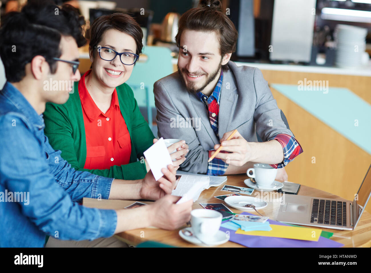 Portrait of three creative people dressed in business casual smiling ...
