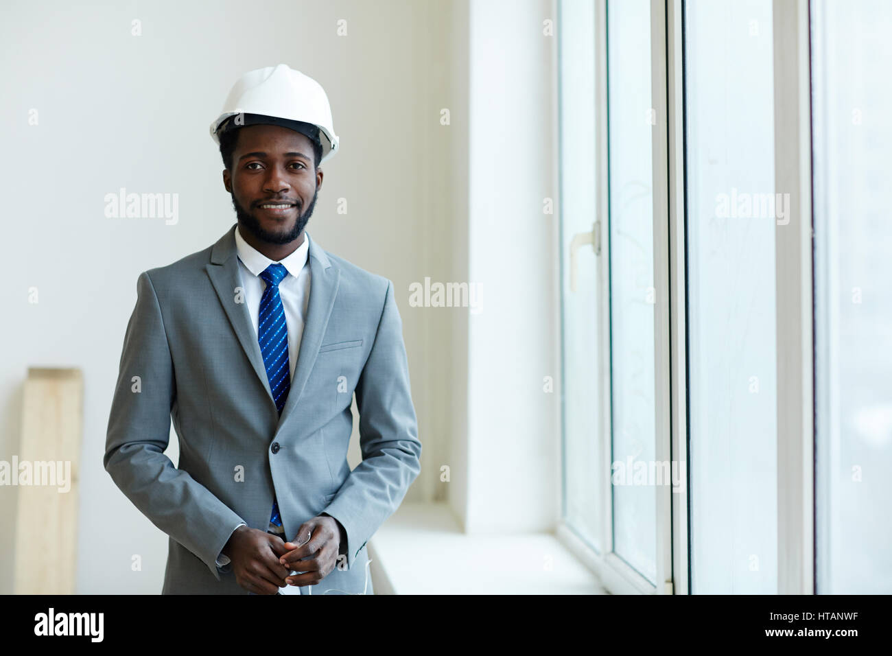 Happy foreman in helmet and suit Stock Photo - Alamy