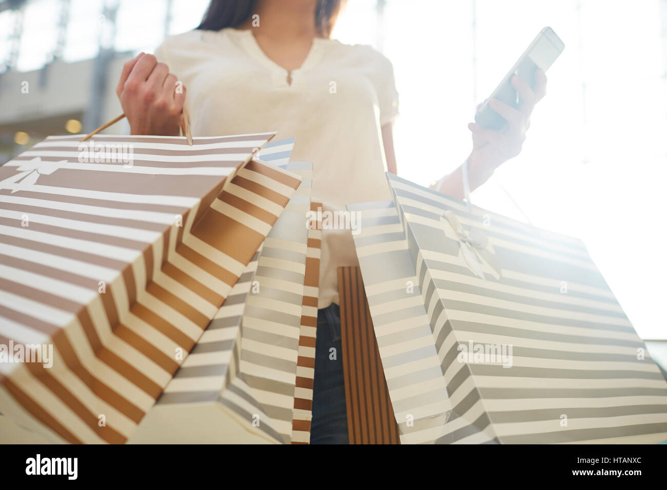 Female shopper with striped paper-bags Stock Photo - Alamy