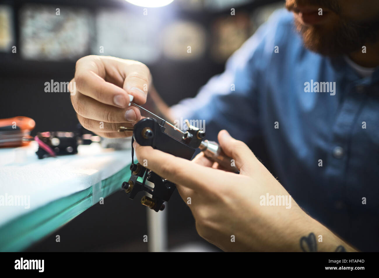 Tattoo master preparing machine for work Stock Photo - Alamy