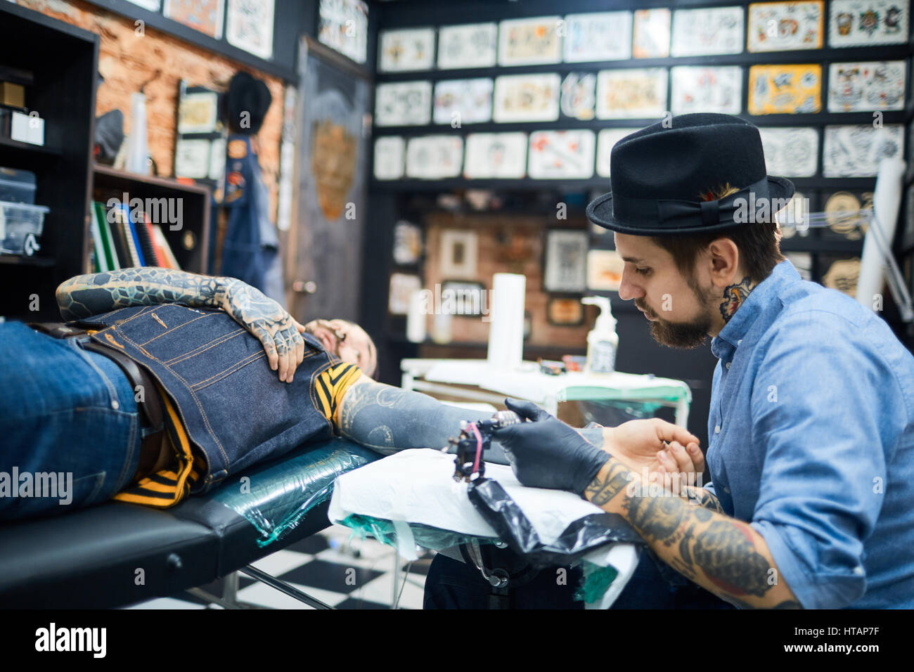 Young man visiting professional tattoo master Stock Photo - Alamy