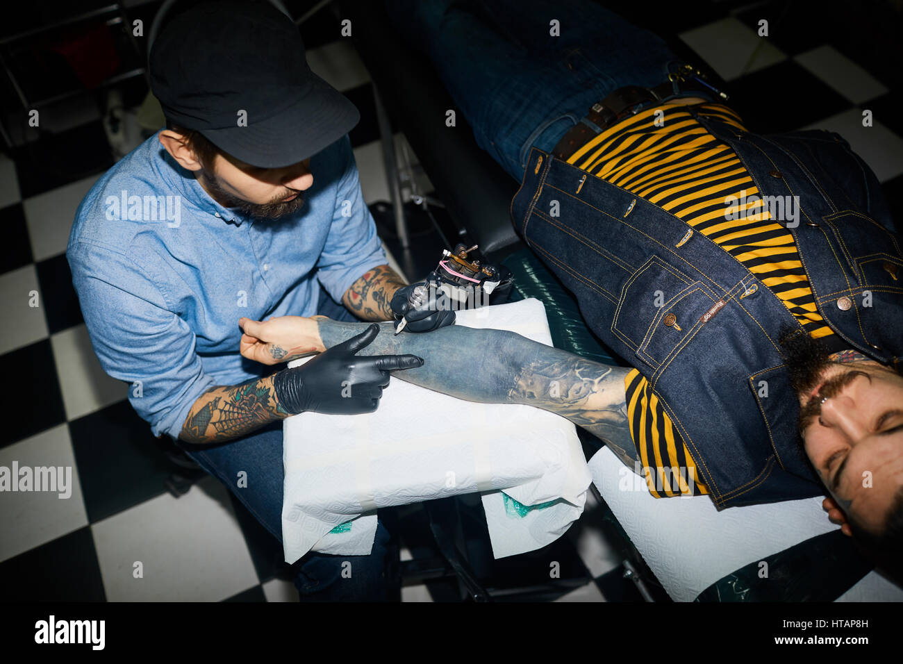 Owner of tattoo salon serving client Stock Photo - Alamy