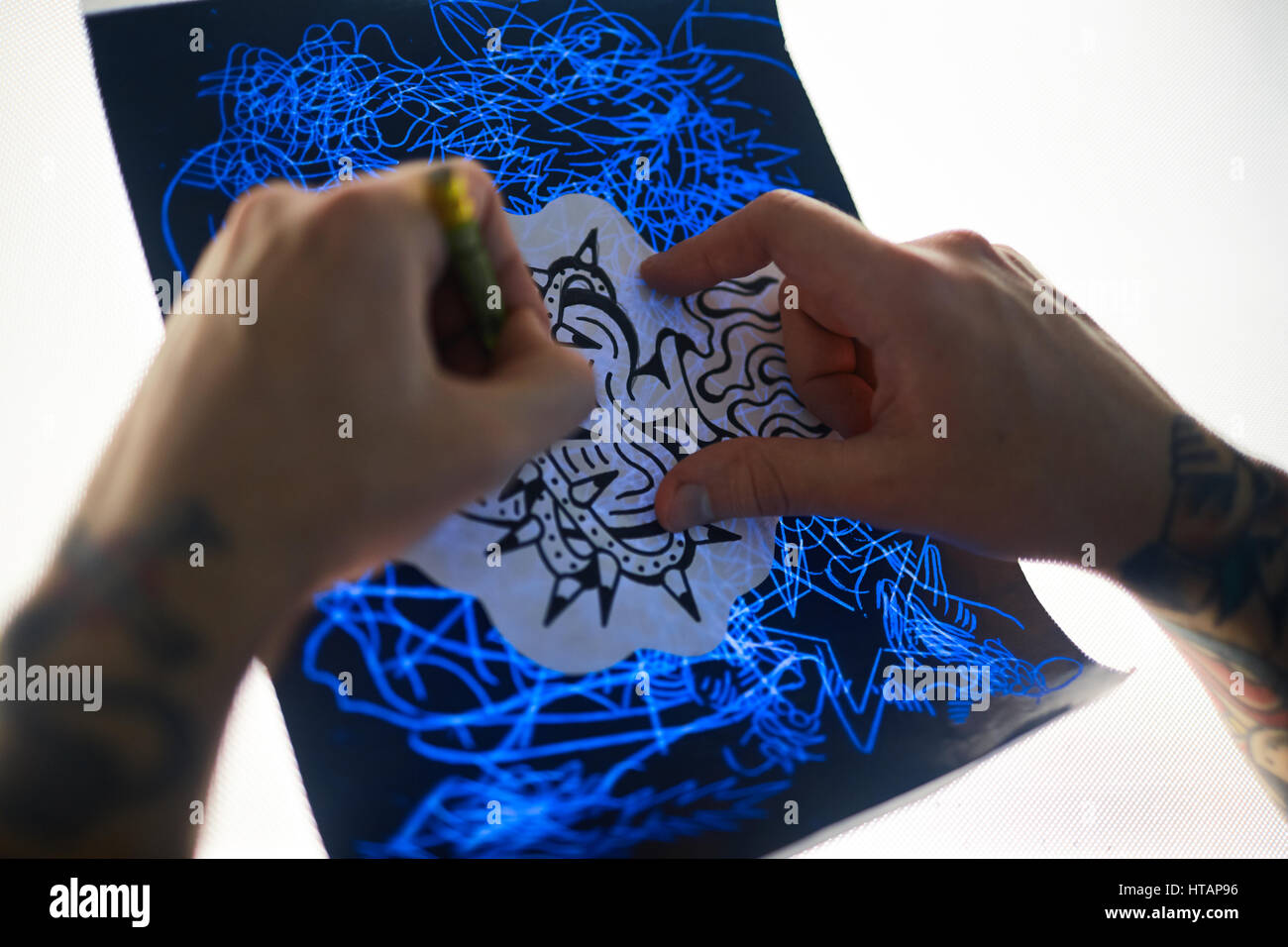 Hands with pencil drawing picture of tattoo adornment Stock Photo - Alamy