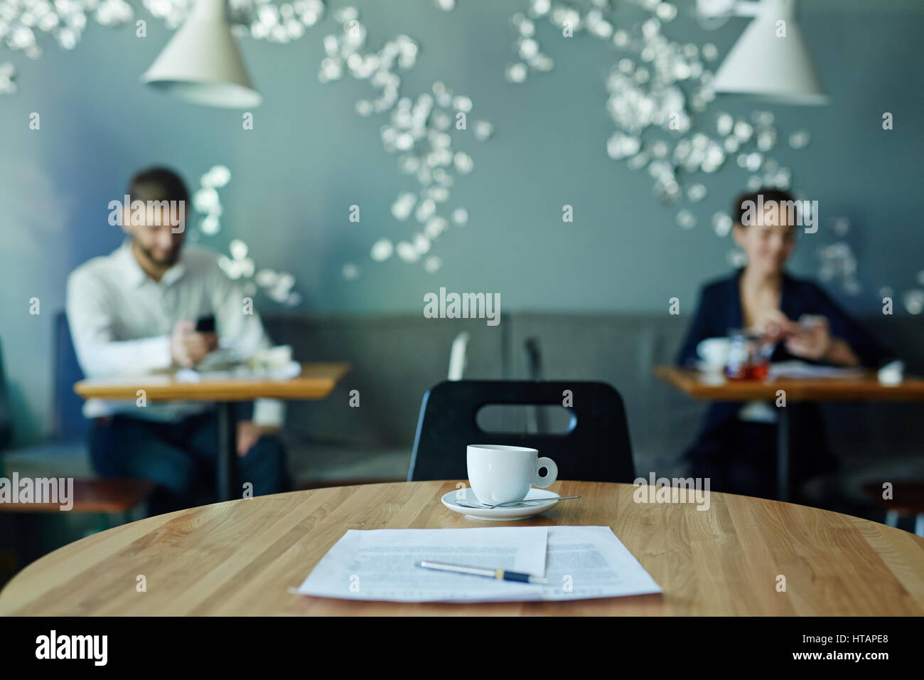 Image of business documents on empty table in cafe with two ...