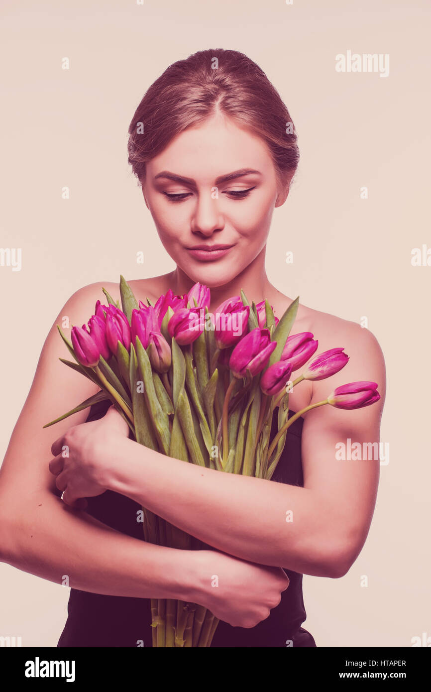 girl on a white background hugging tulips Stock Photo - Alamy