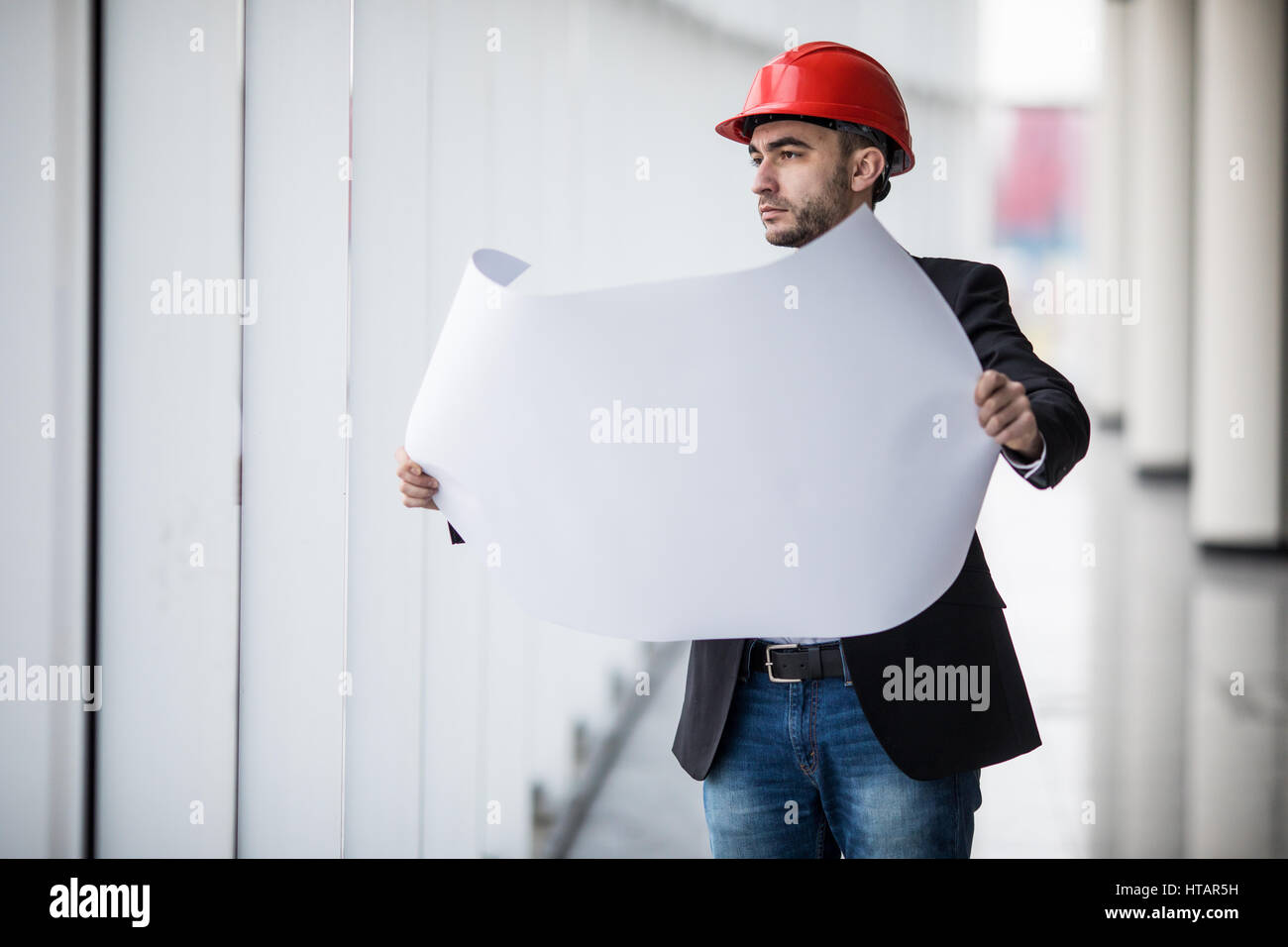 Portrait of an architect builder studying layout plan of the building ...