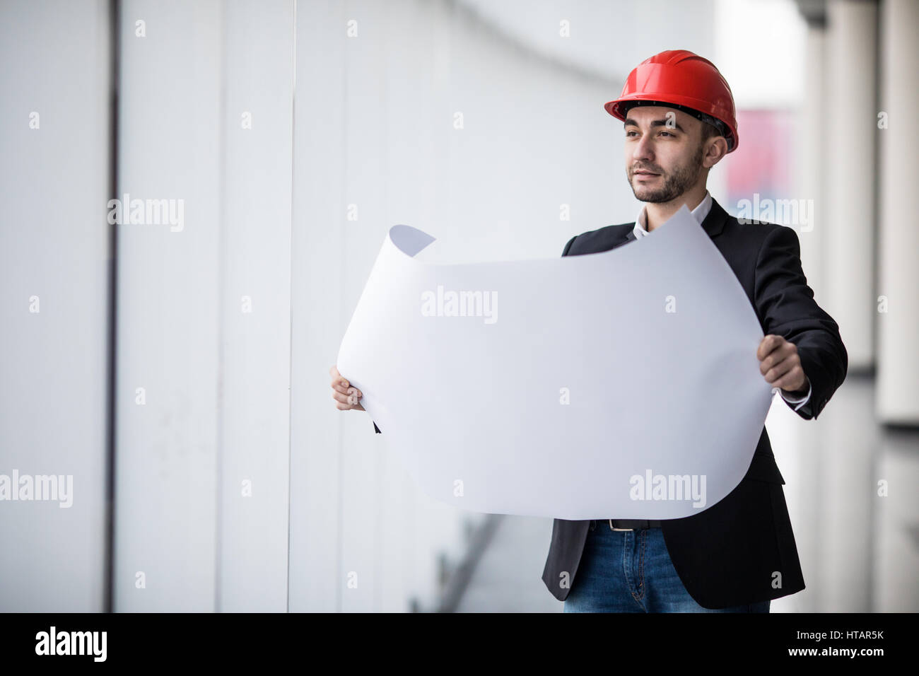 Portrait of an architect builder studying layout plan of the building ...