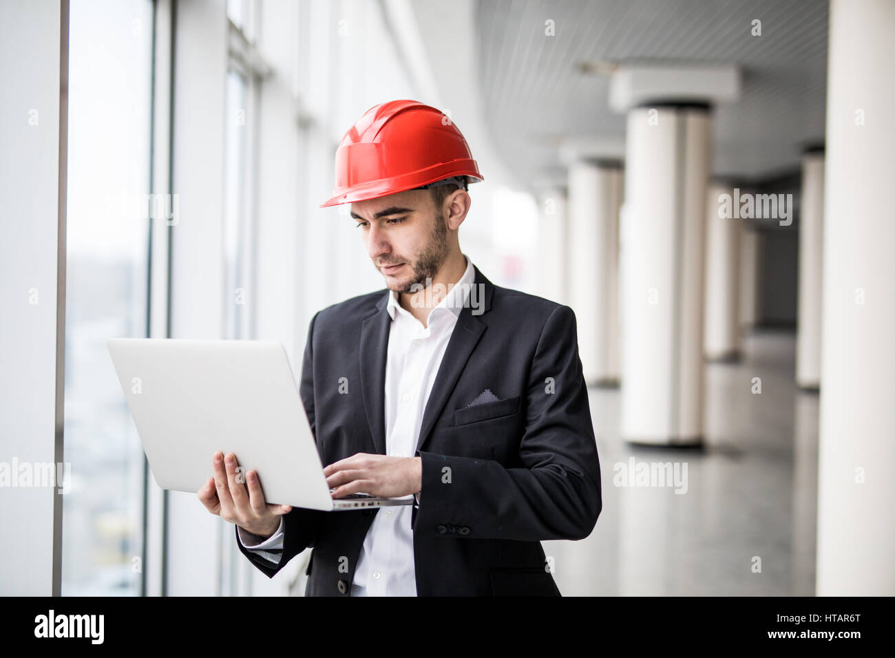 Handsome male engineer is using a notebook for work. The man is a white ...